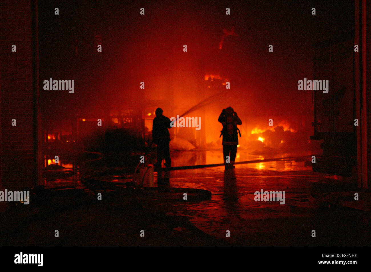 Firefighters putting out a fire Stock Photo - Alamy