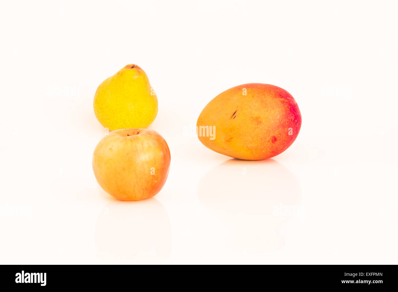 A pear beside a mango with an apple Stock Photo - Alamy