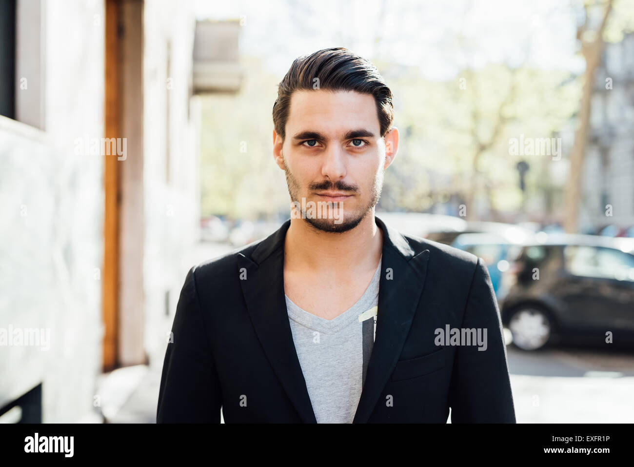 Portrait of a young handsome italian boy posing through the street of ...