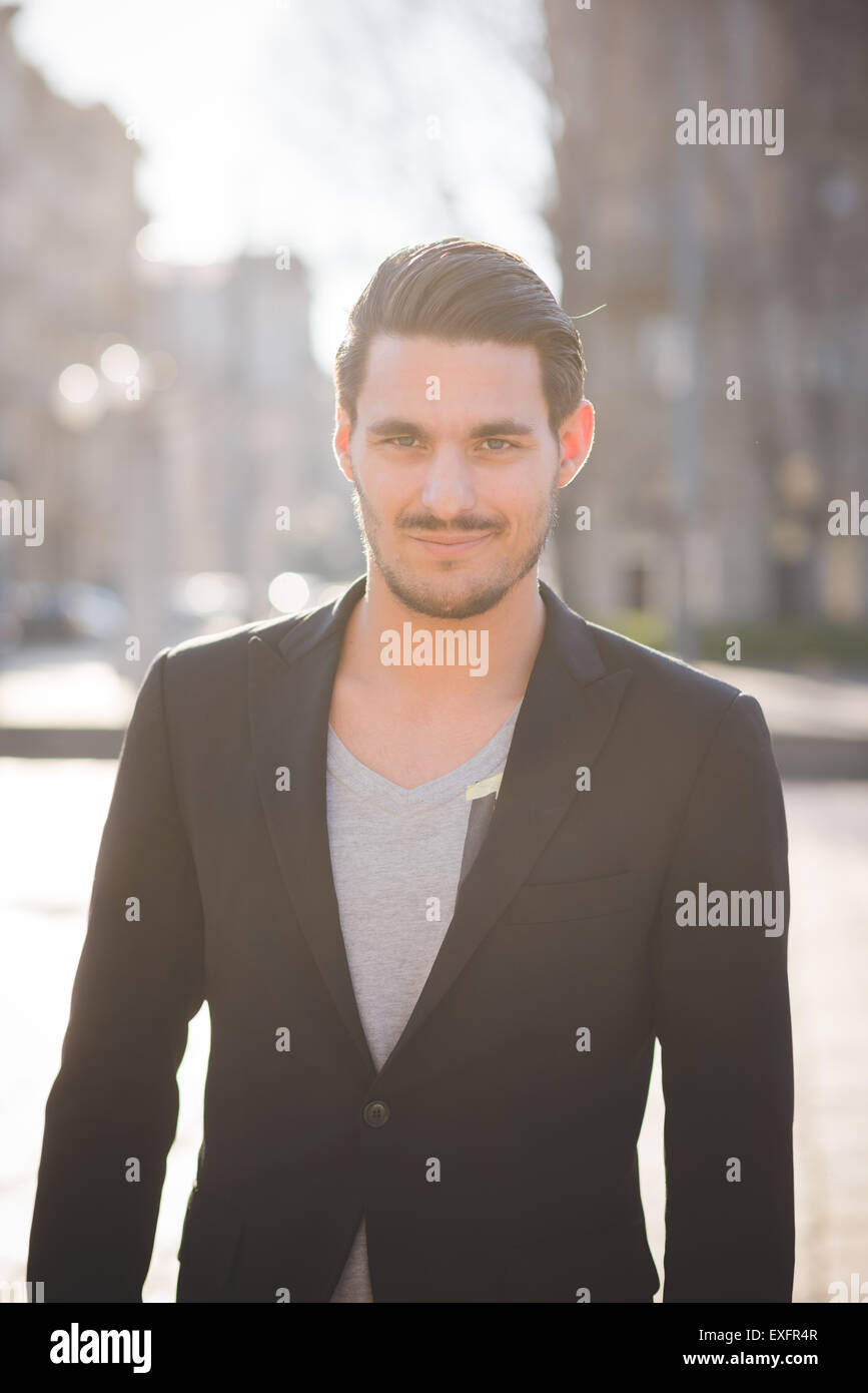 Portrait of a young italian boy posing through the street of the city ...
