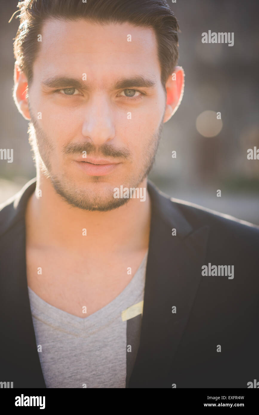 Portrait of a young italian boy posing through the street of the city ...