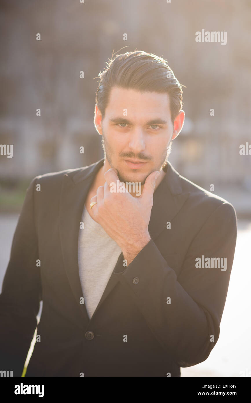 Portrait of a young italian boy posing through the street of the city ...