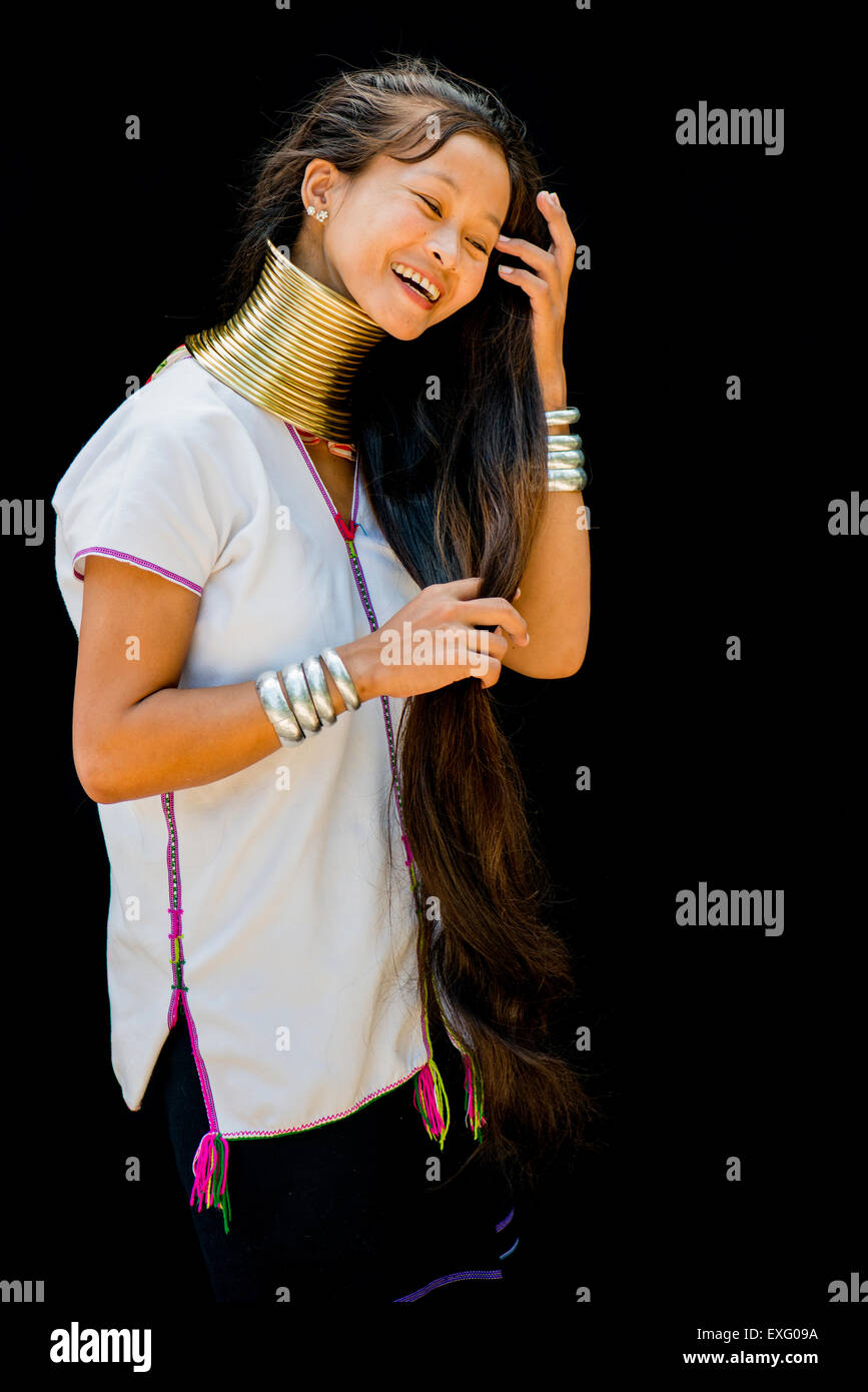 Young Kayan hill tribe woman doing her hair against a black background ...