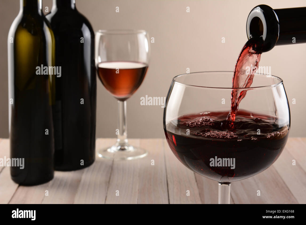 Closeup of a glass of wine and a bottle pouring. Out of focus wine ...