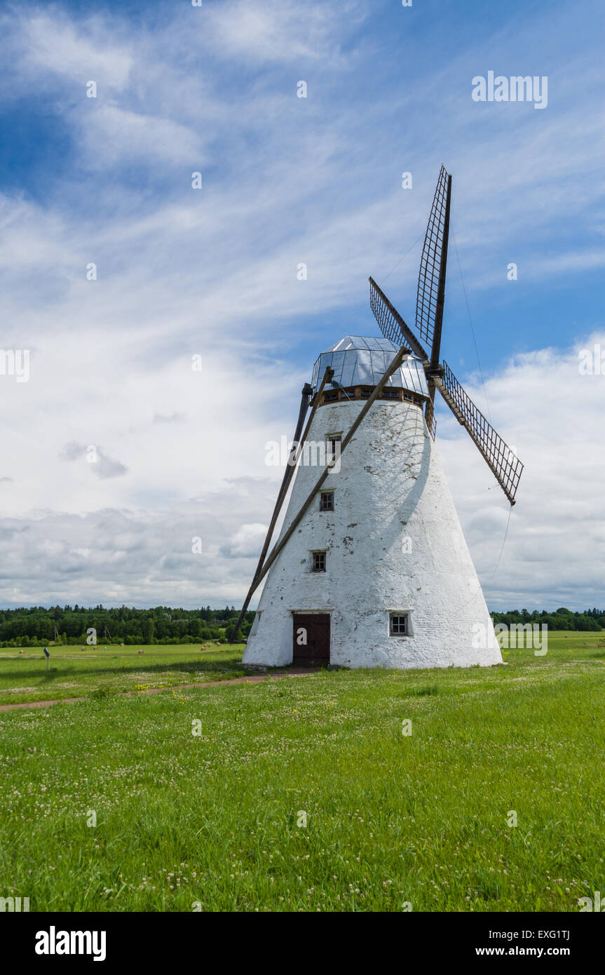 Old stone windmill in a grass field on a summer day, traditional rural ...