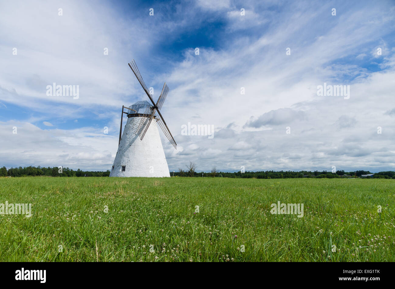 Large white windmill in a grass field on a summer day, classic rural ...