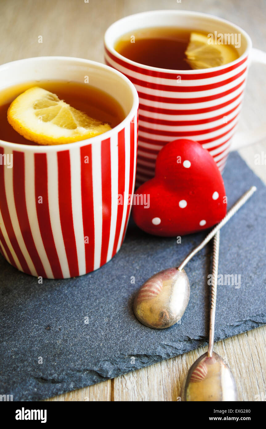 Red tea cup with tea and lemon on the old wooden background with note ...