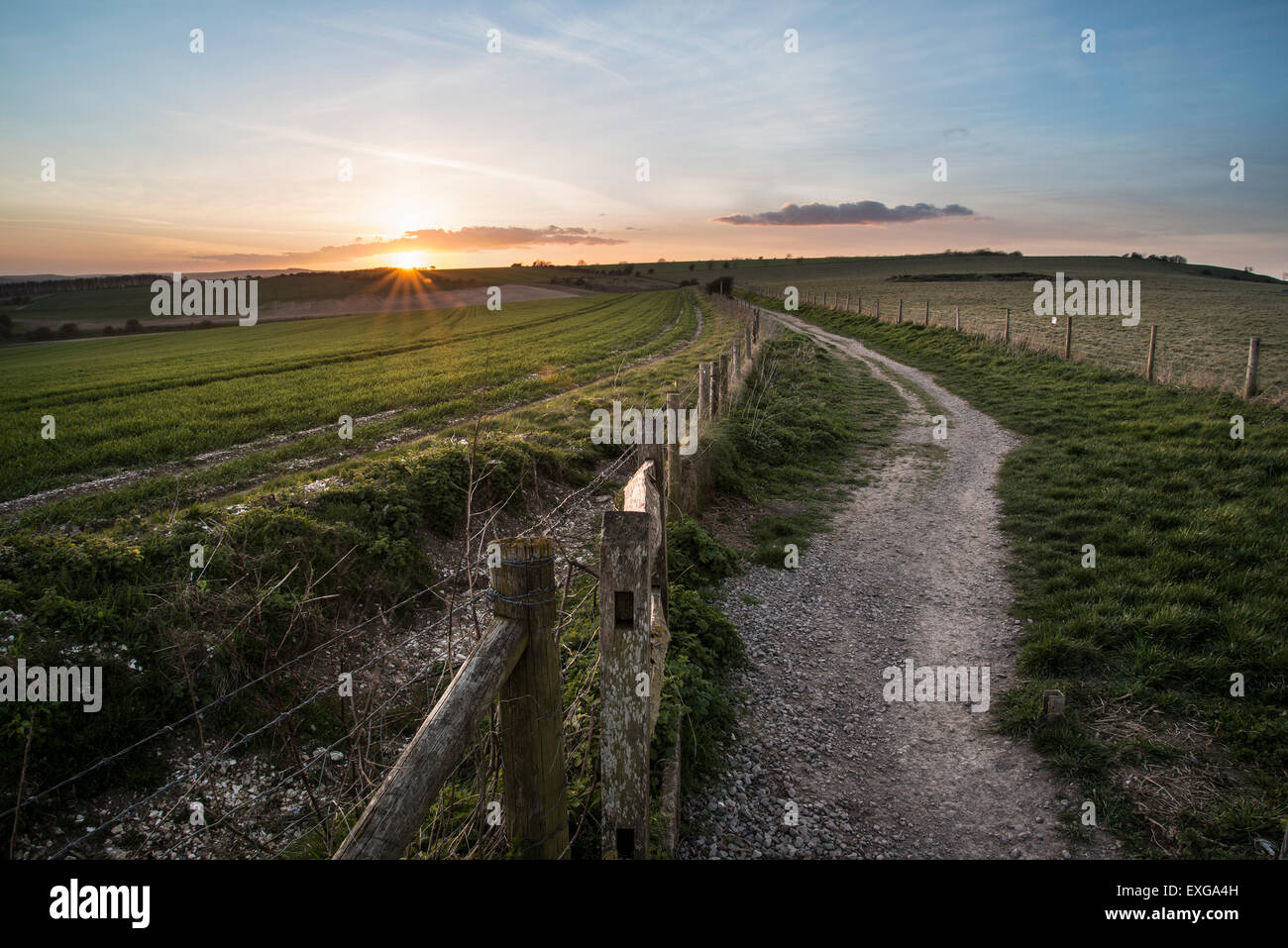 Beautiful Spring landscape of gate leading into fields with setting sun ...