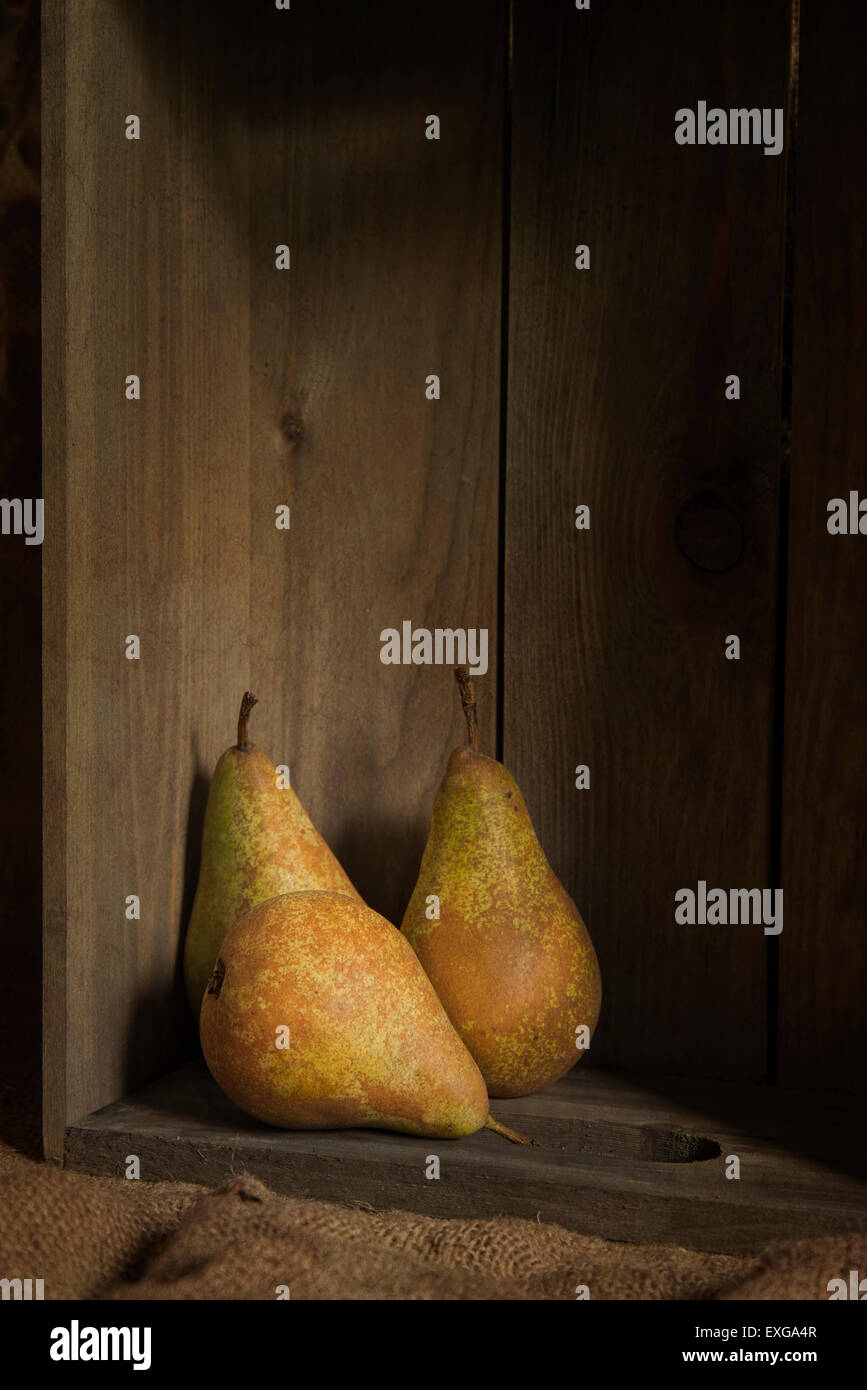 Pears in rustic setting with wooden box and hessian sack with added ...