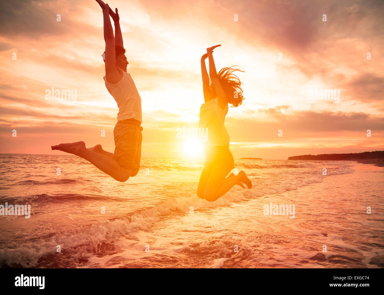 Silhouette of man and woman jumping on beach hi-res stock photography ...