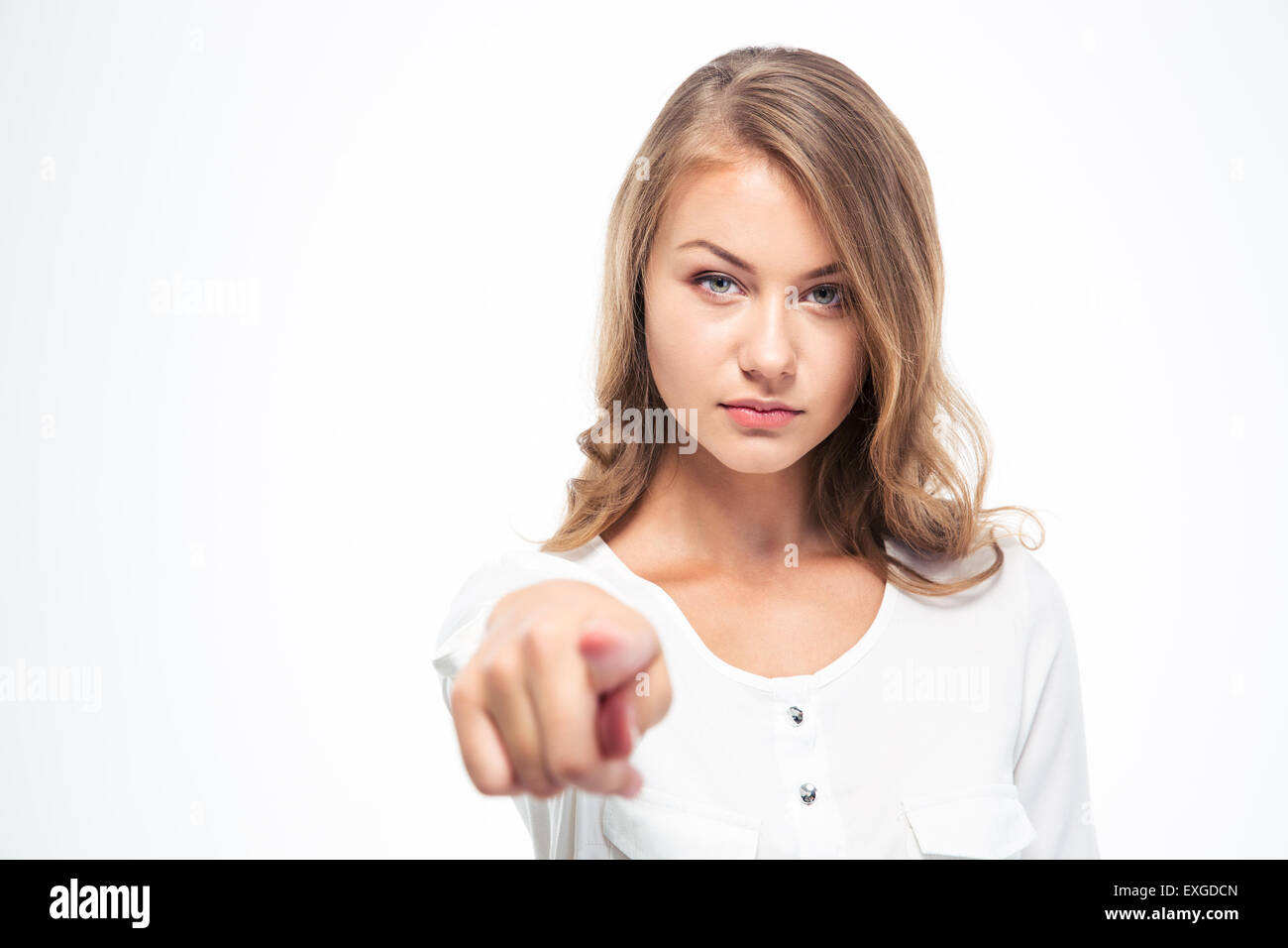Young beautiful woman pointing finger at camera isolated on a white ...