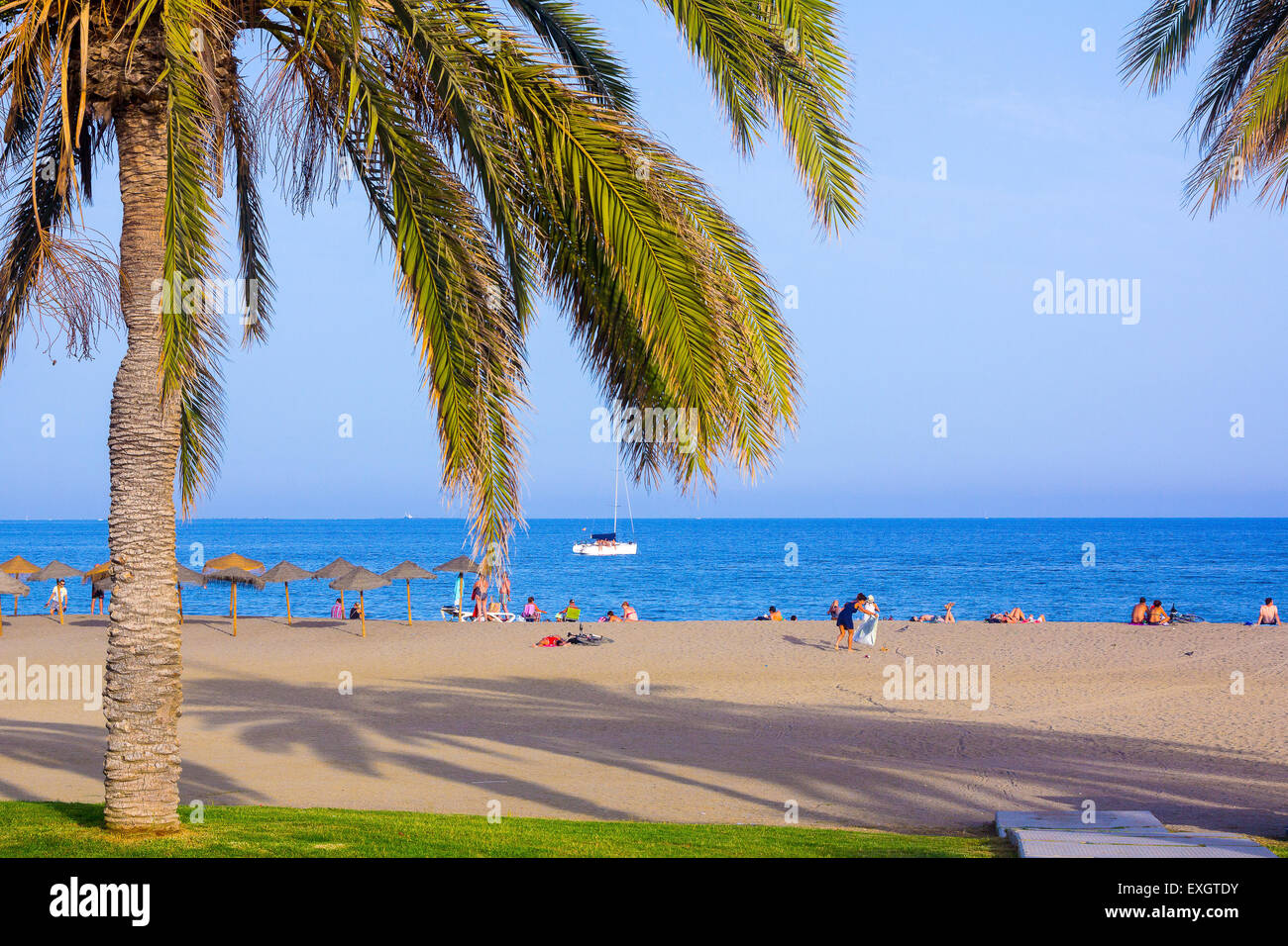 Travel Malagueta beach with palm trees and blue sea in Malaga Spain ...