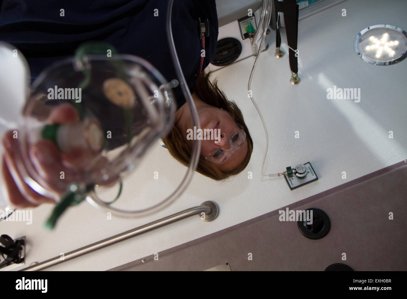 Female EMT giving patient oxygen in the back of an ambulance Stock ...