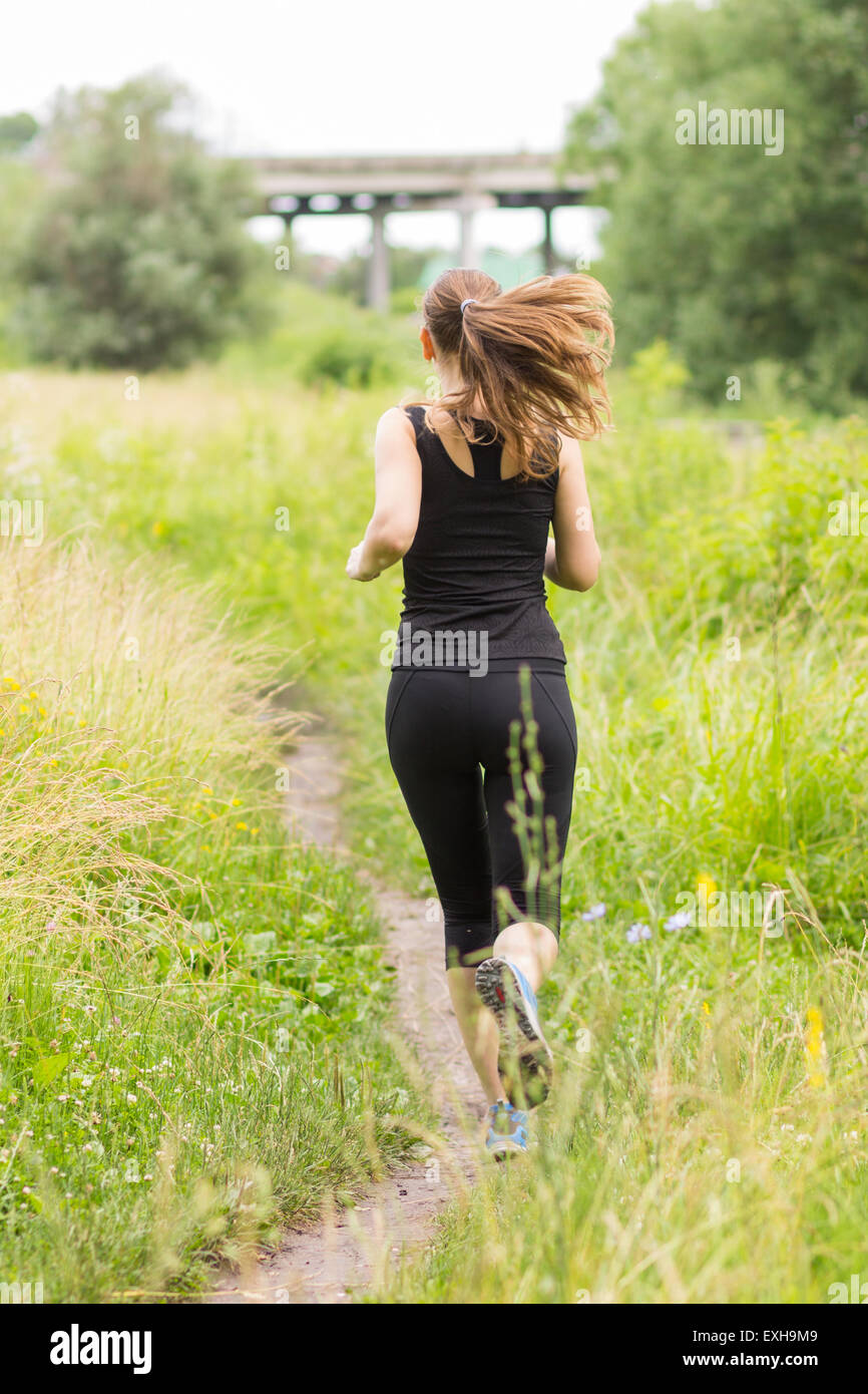 Jogging woman at summer midday. Sport fitness girl make exercises at ...