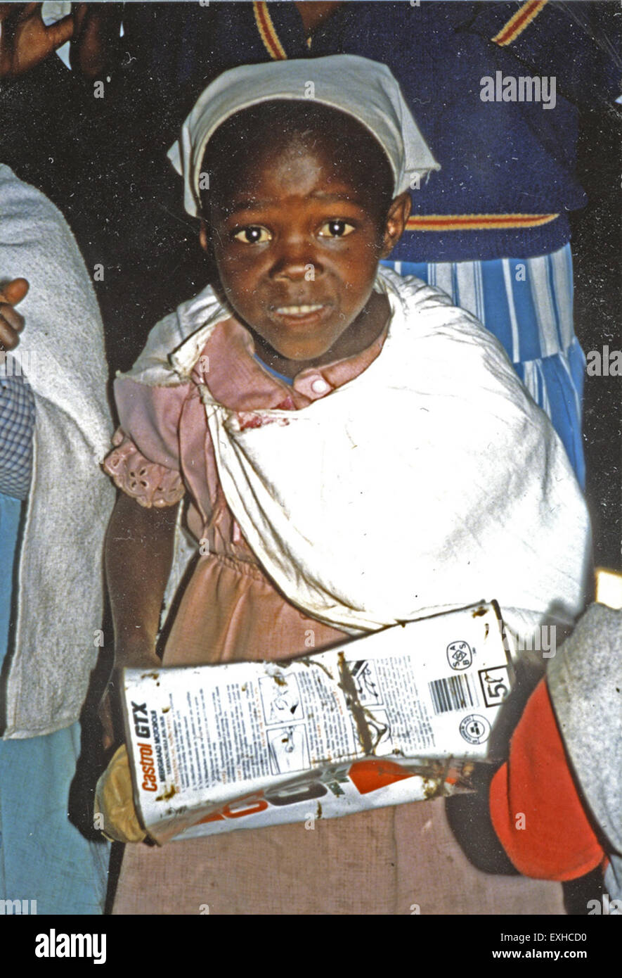 A girl uses an oil tin as a percussion instrument during worship ...