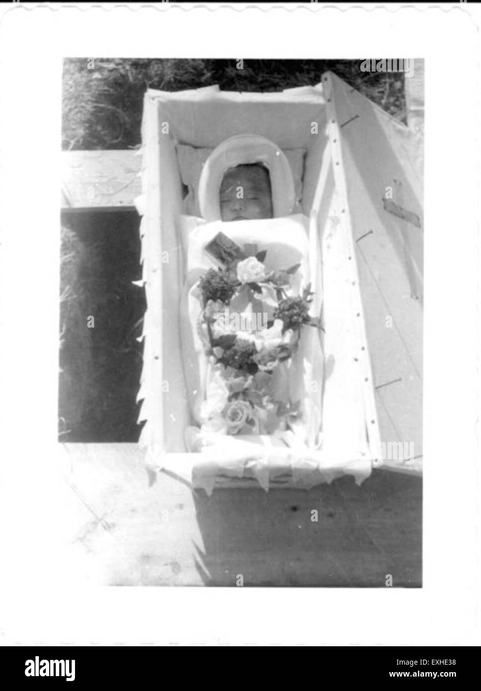 This image shows an infant in a casket, part of a poignant scene in ...