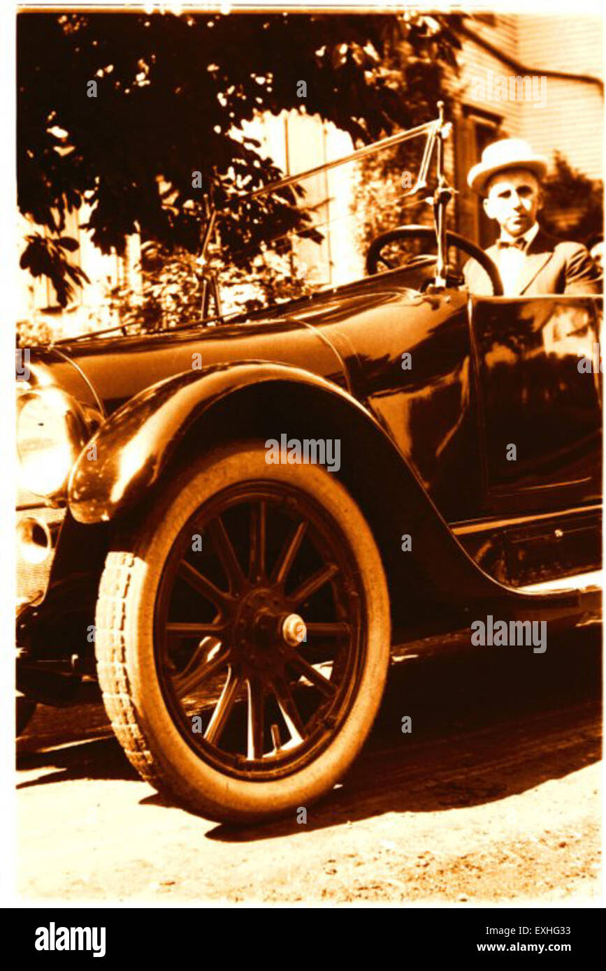 This image features a man sitting in a car, captured by photographers ...