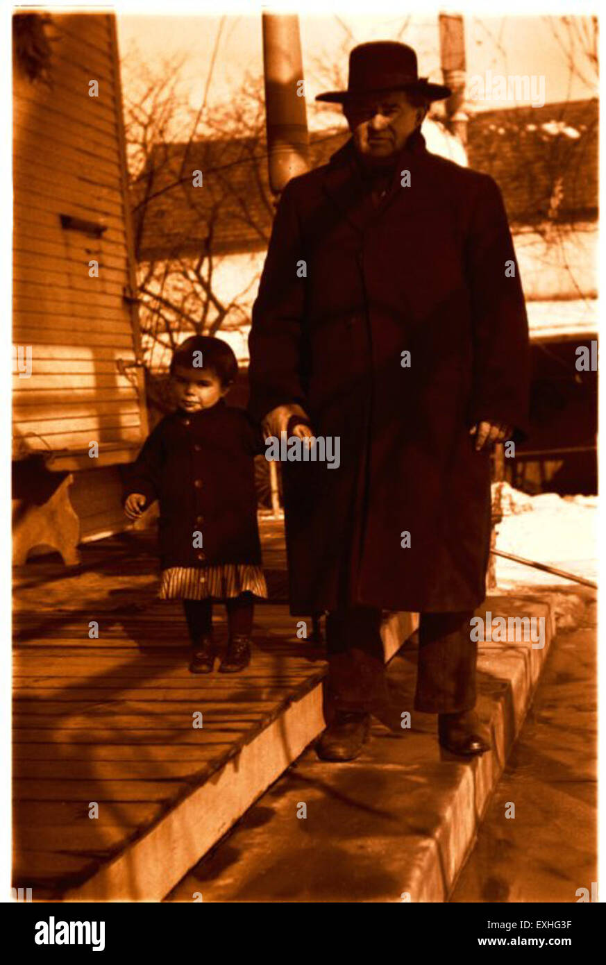 This portrait depicts a man in a hat with a child wearing a hat ...