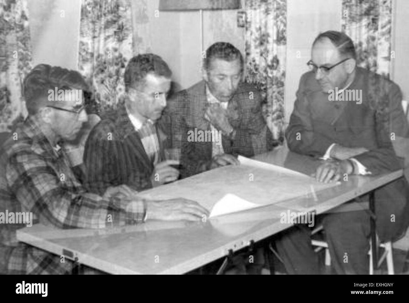 The painting *Men discussing home missions* explores themes of faith ...