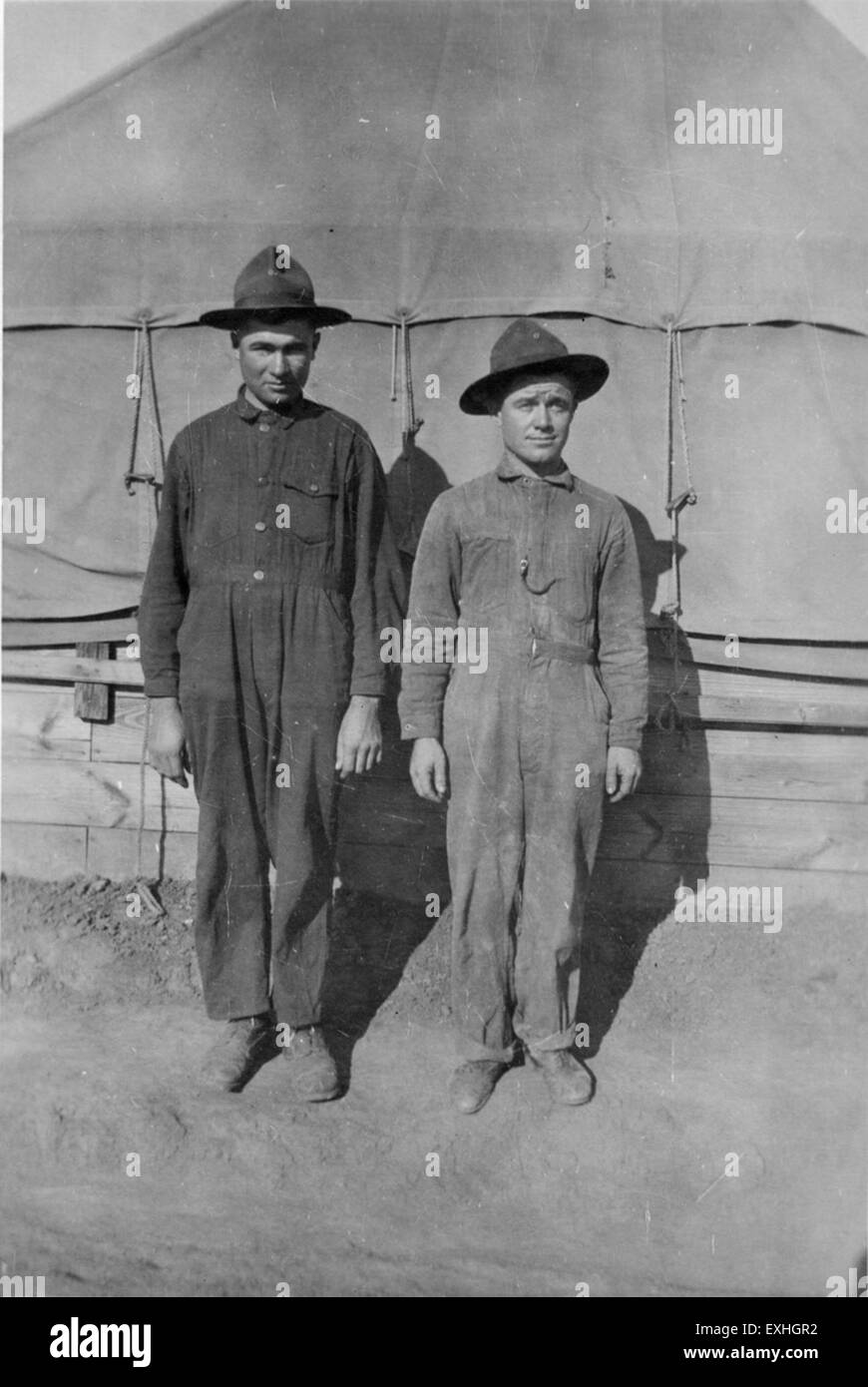 The photograph shows a group of men standing outside a tent at Camp ...