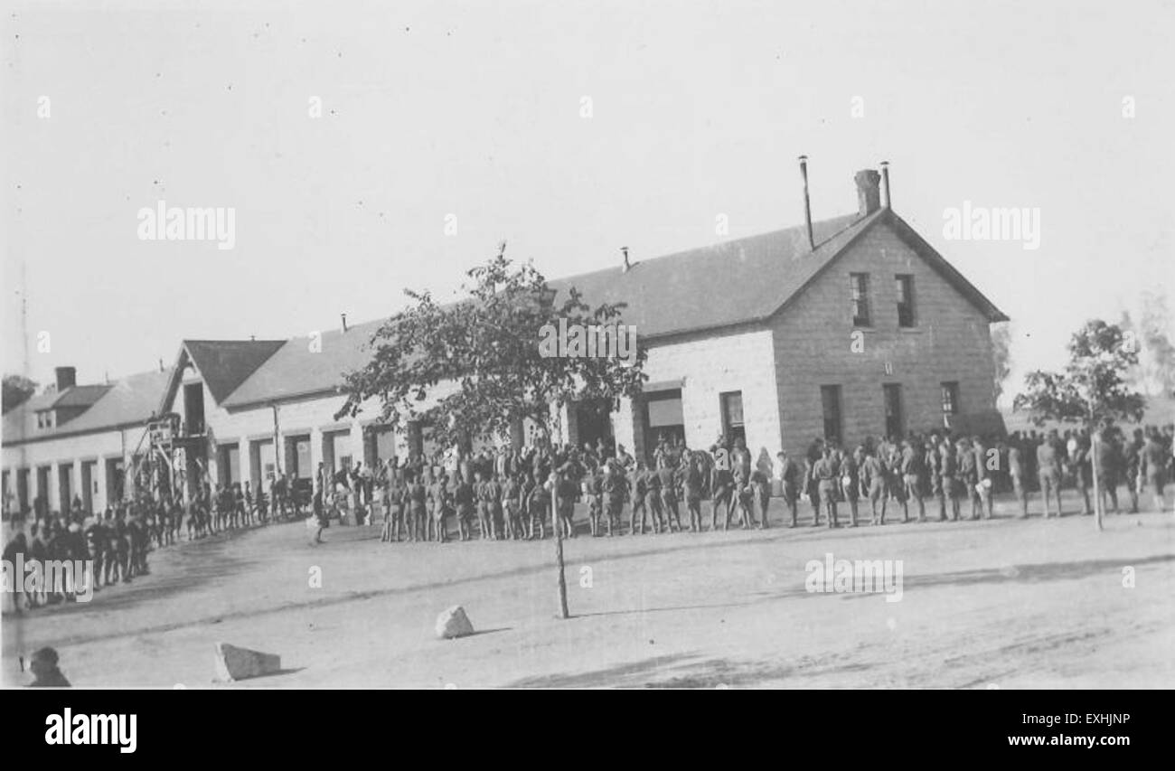 This photograph shows a line of personnel in a mess hall, likely during ...