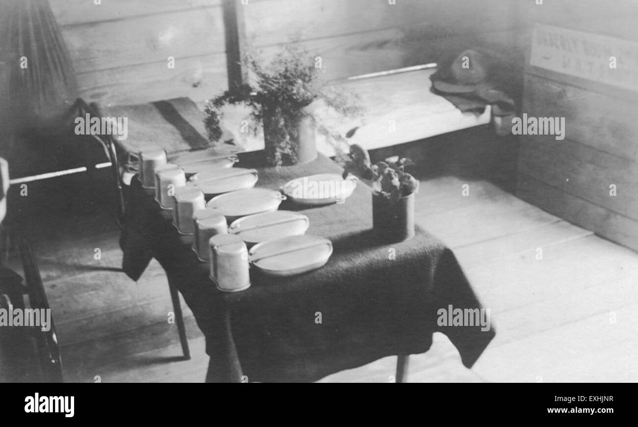 The image features a set of military mess kits arranged on a table ...