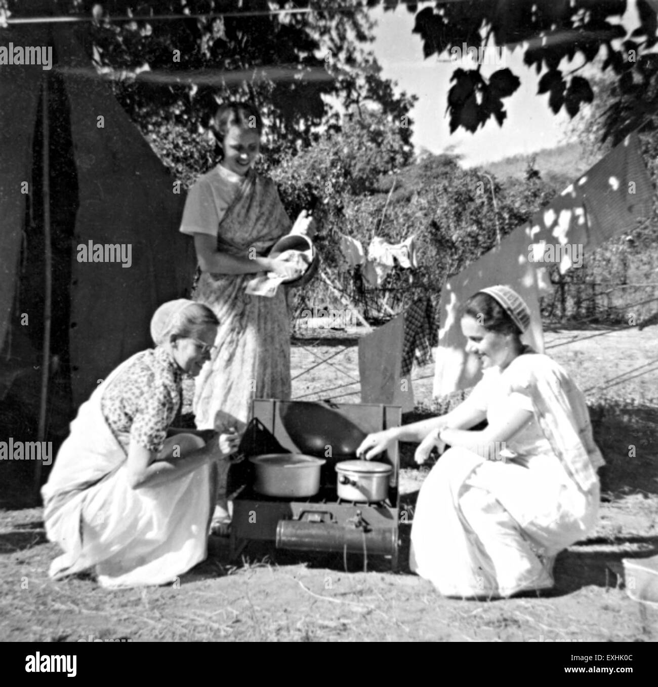 This photograph from 1955 shows missionaries preparing a meal at a tent ...