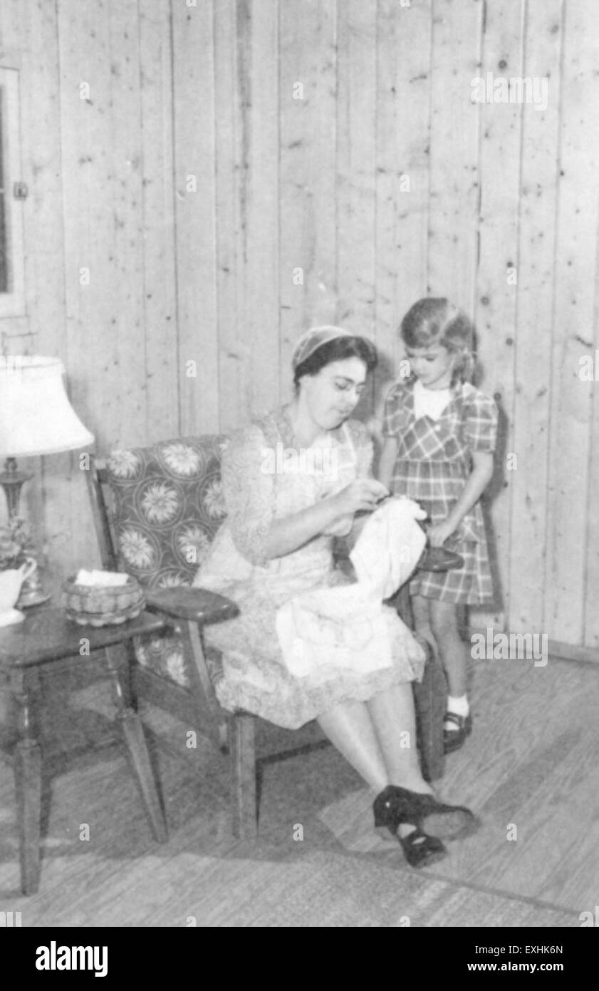 A Mennonite mother and daughter are depicted engaging in sewing ...