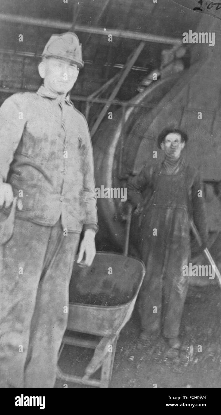 This image captures two men working, possibly in a rural or industrial ...