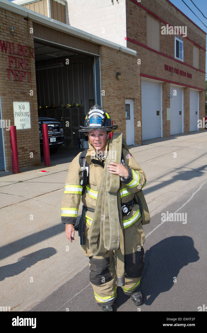 Female firefighter in rural volunteer fire department working with ...