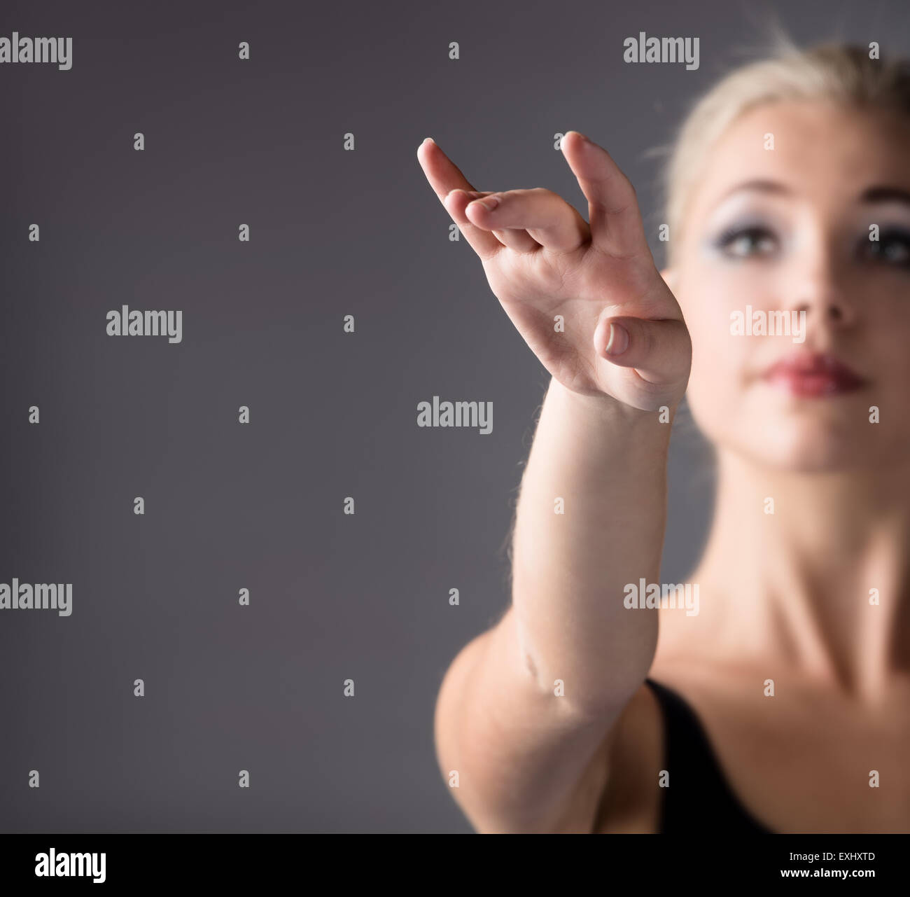 Portrait of a beautiful female ballet dancer on a grey background ...