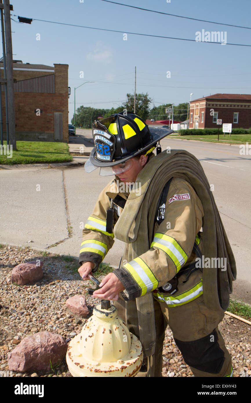Female firefighter in rural volunteer fire department working with ...