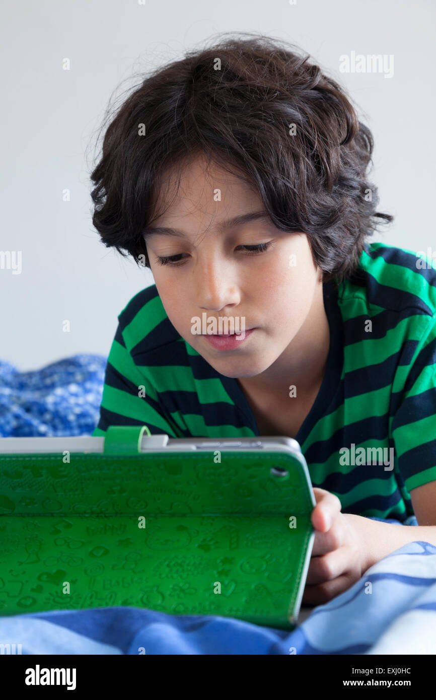 Teenage boy looking surprised at his digital tablet Stock Photo - Alamy
