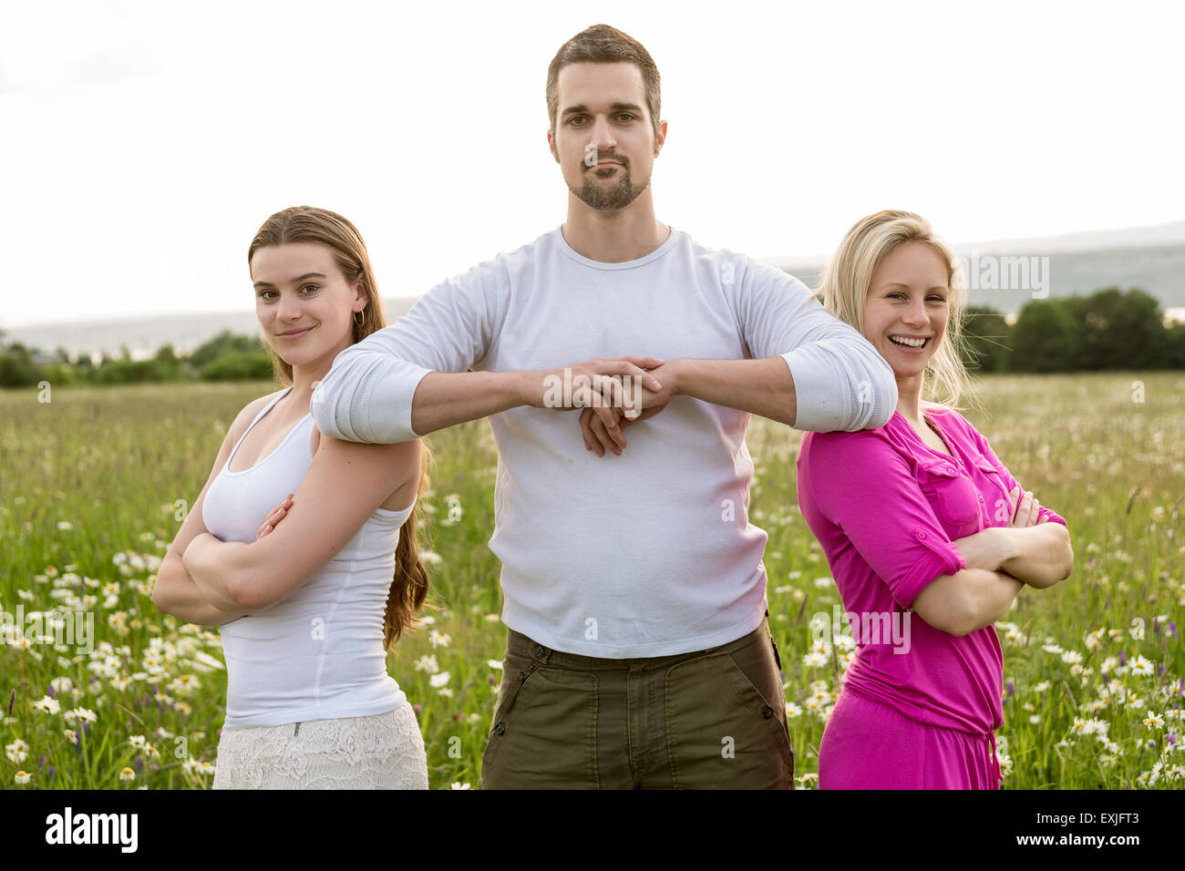 Three happy friends spending free time together in a field Stock Photo ...