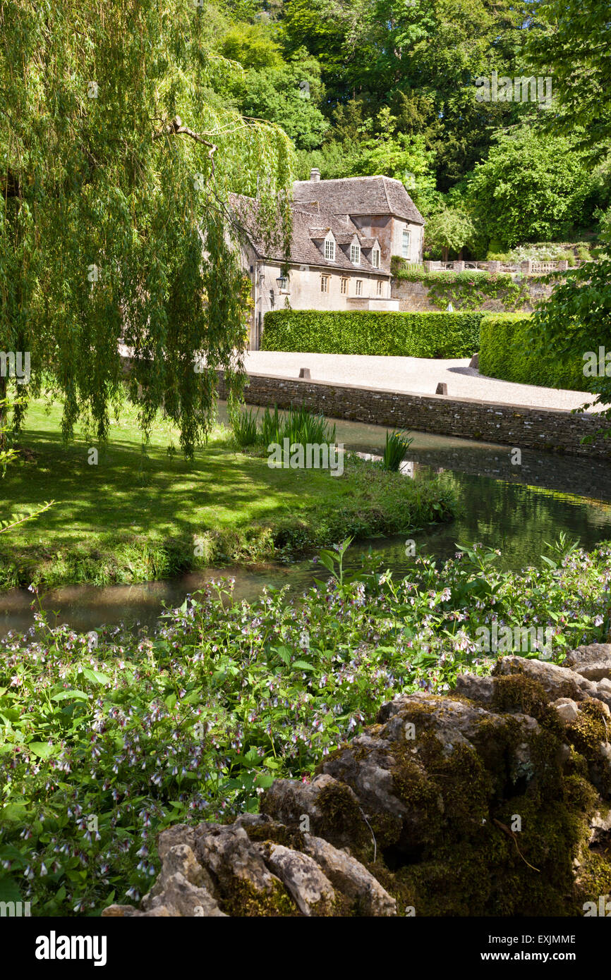 An old mill beside the young River Coln in the Cotswold village of Coln ...
