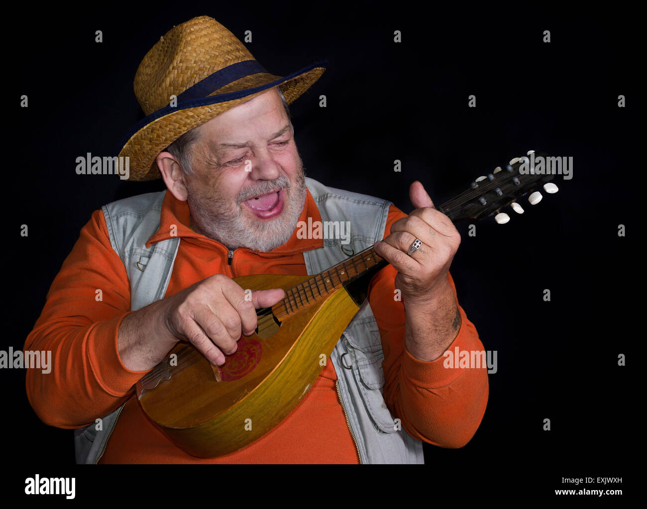 Senior musician with mandolin playing and singing country music on a ...