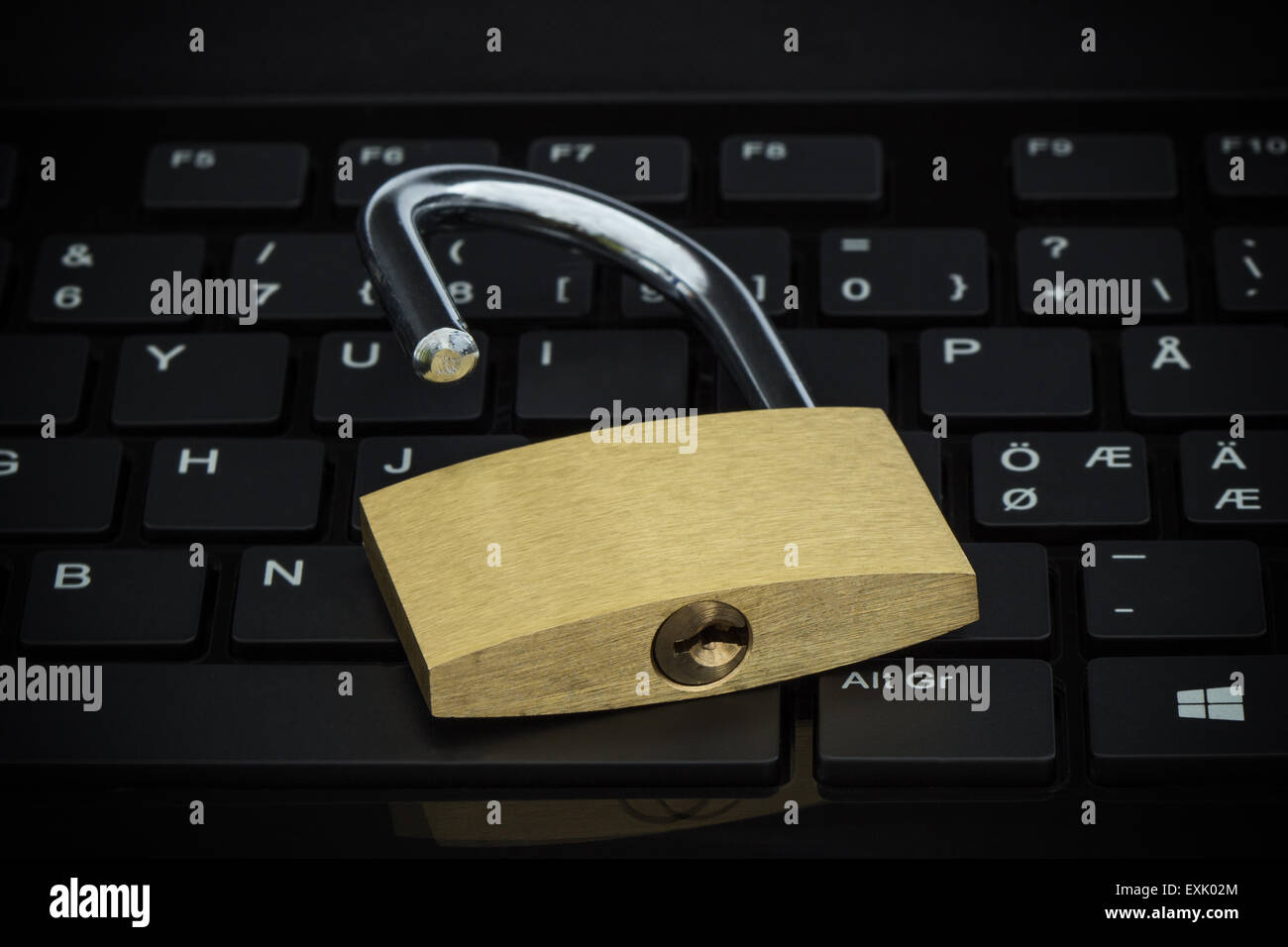 Close-up of a unlocked padlock on a computer keyboard. Concept photo of ...