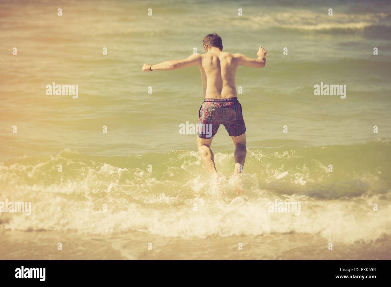 Man jumping in sea water. Summertime photo with sea shore and man ...