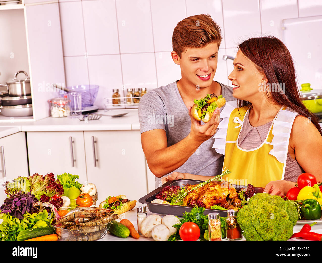 Couple cooking chicken at kitchen Stock Photo - Alamy