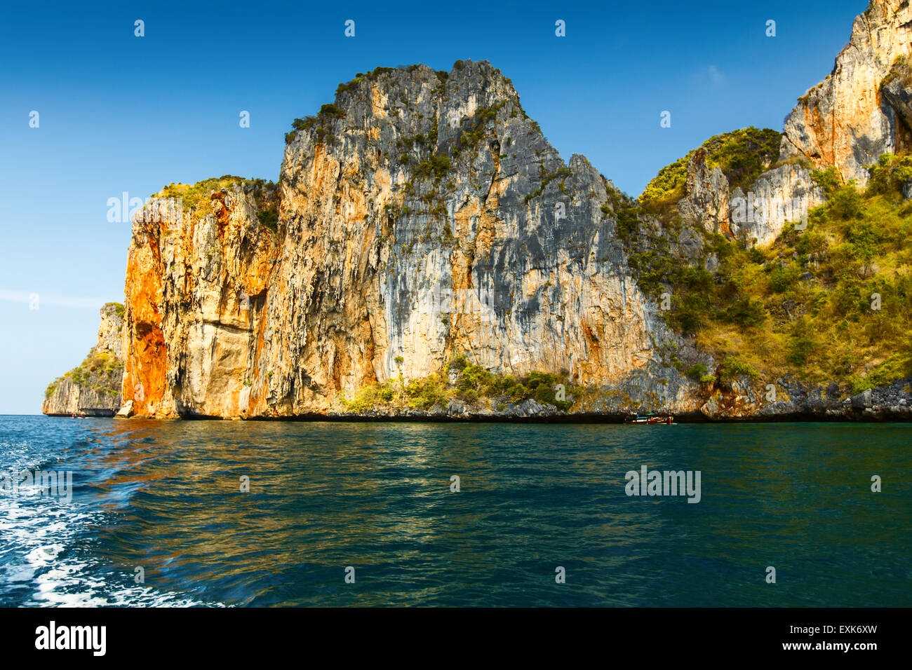 Tropical rock island with green stones on deep blue summer sea ...