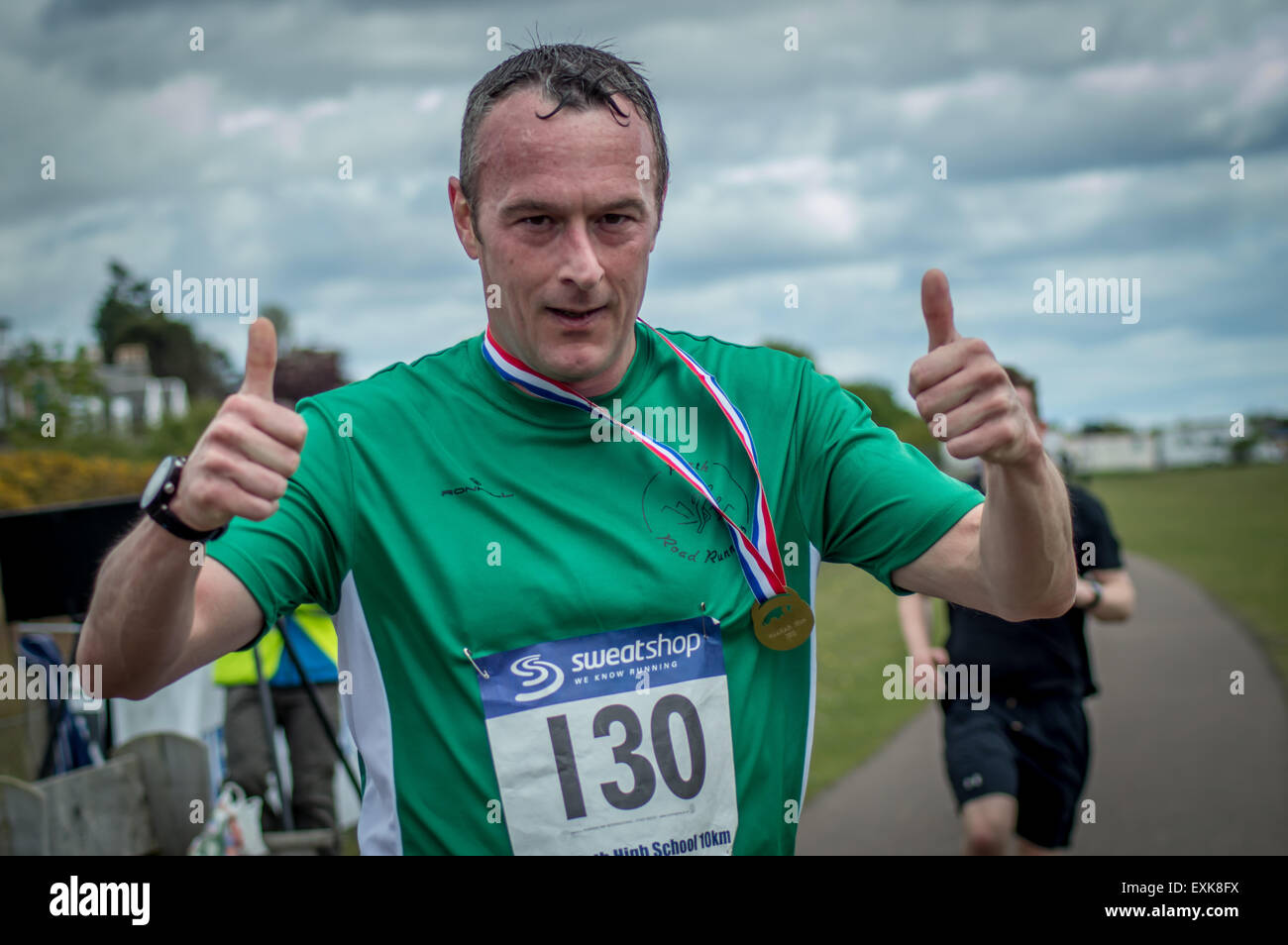 Male runner thumbs up on the finish line Stock Photo - Alamy
