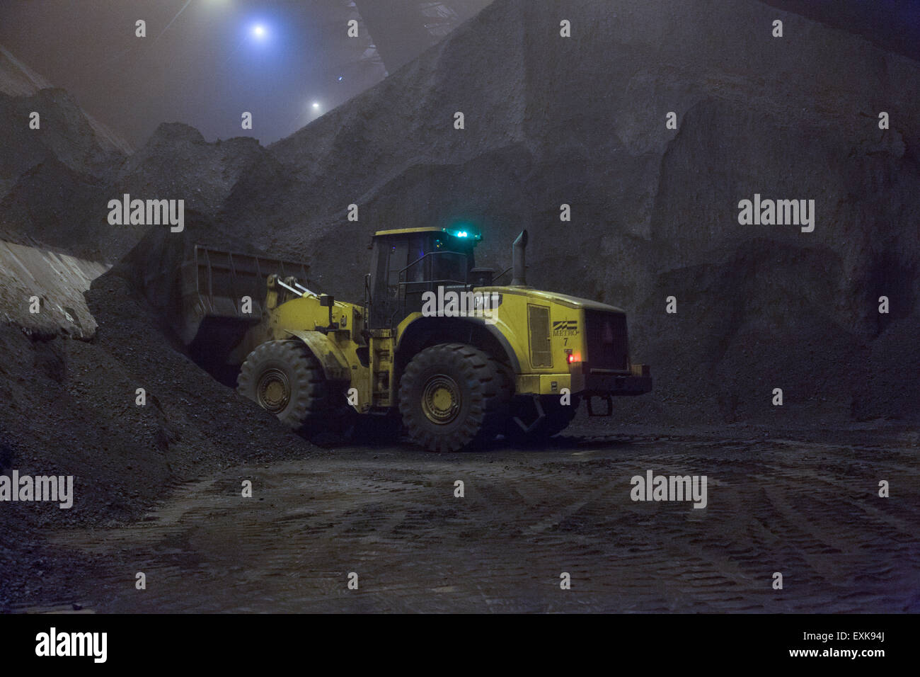 frontloader working in a warehouse with coal or coke carbon Stock Photo ...