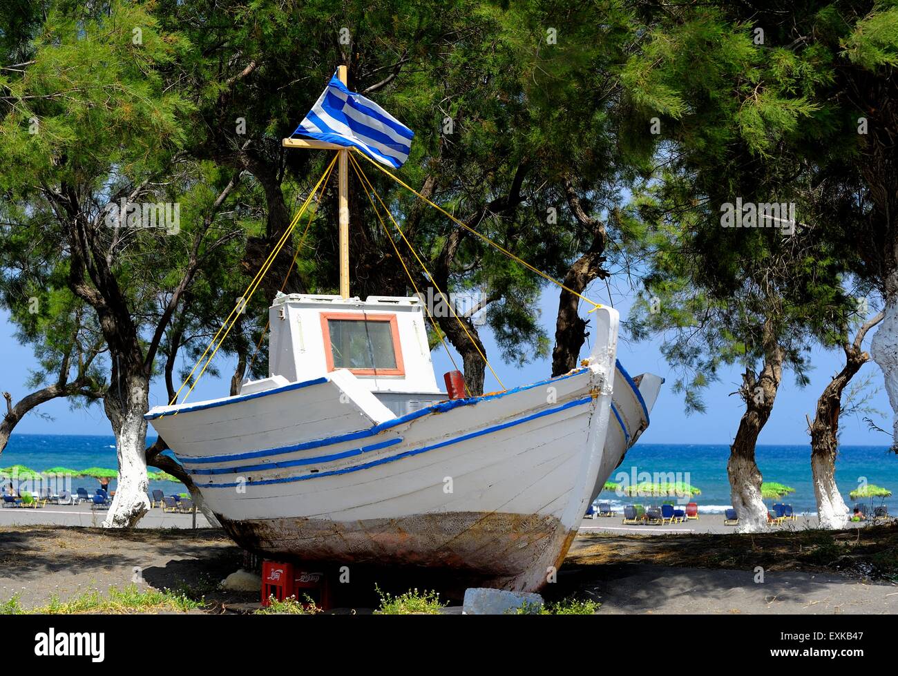 A boat on monolithos beach flying the Greek flag Santorini Greece Stock ...