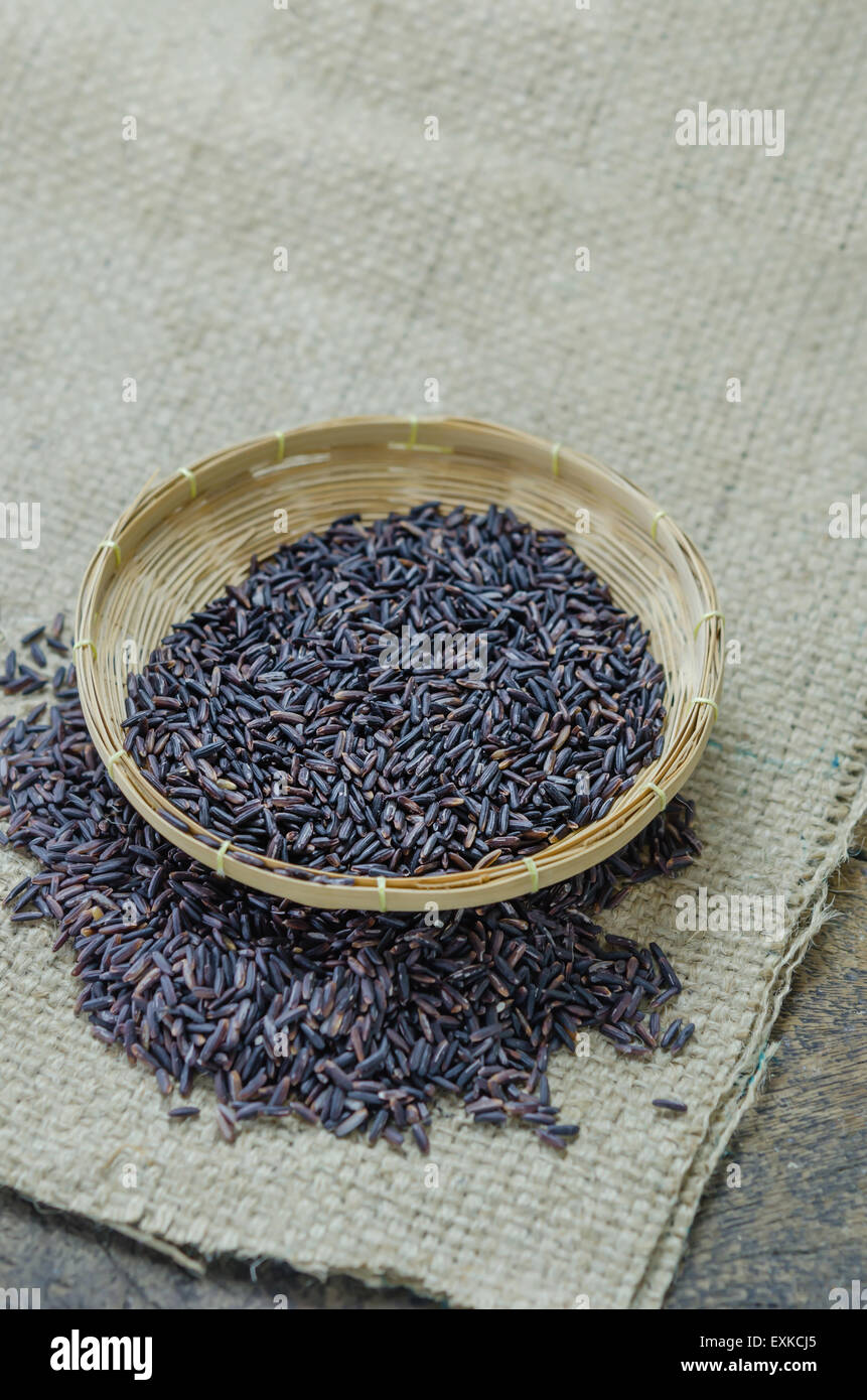 raw purple Riceberry rice in bamboo basket with wooden spoon Stock ...