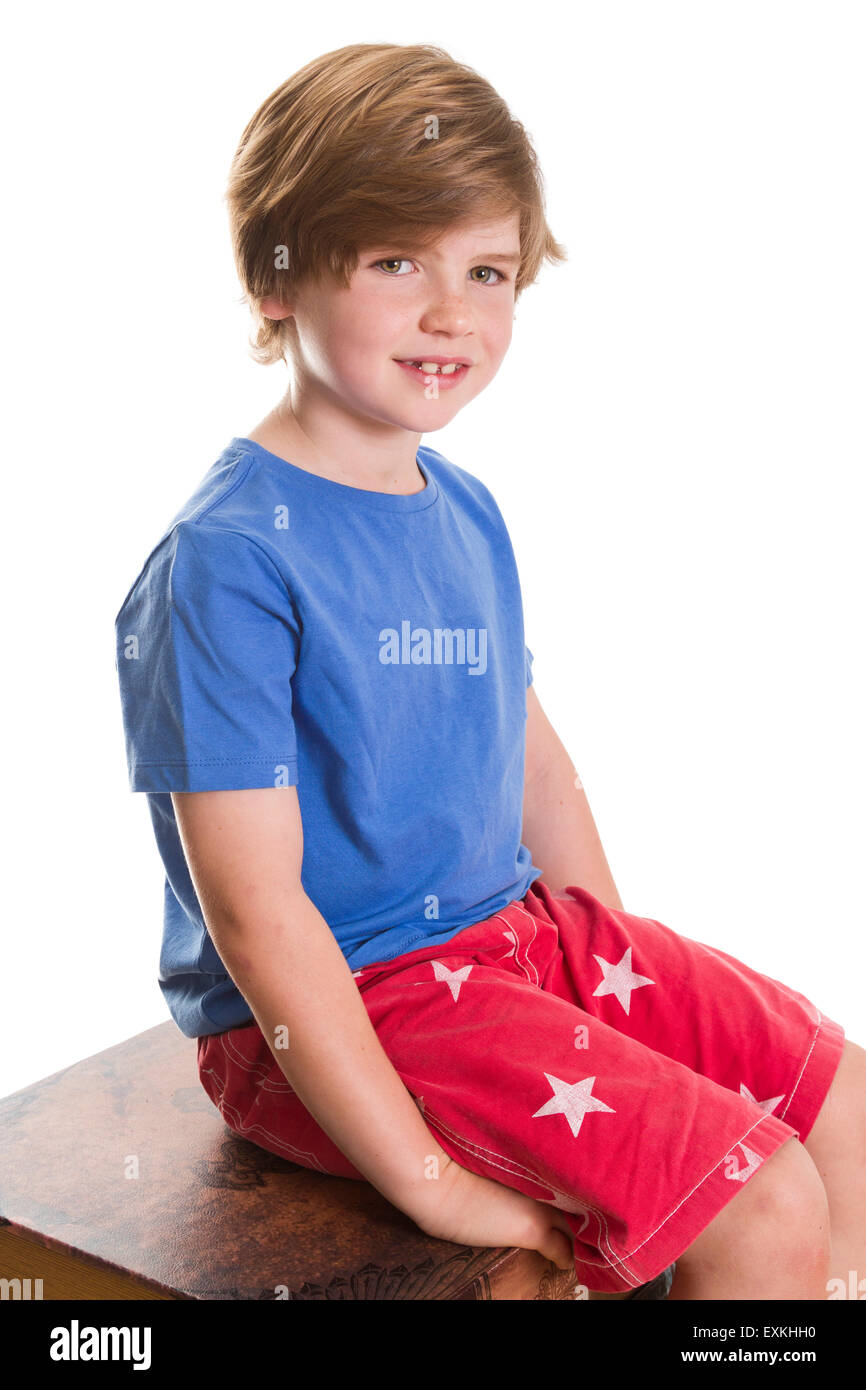 Young boy sitting and smiling at the camera Stock Photo - Alamy