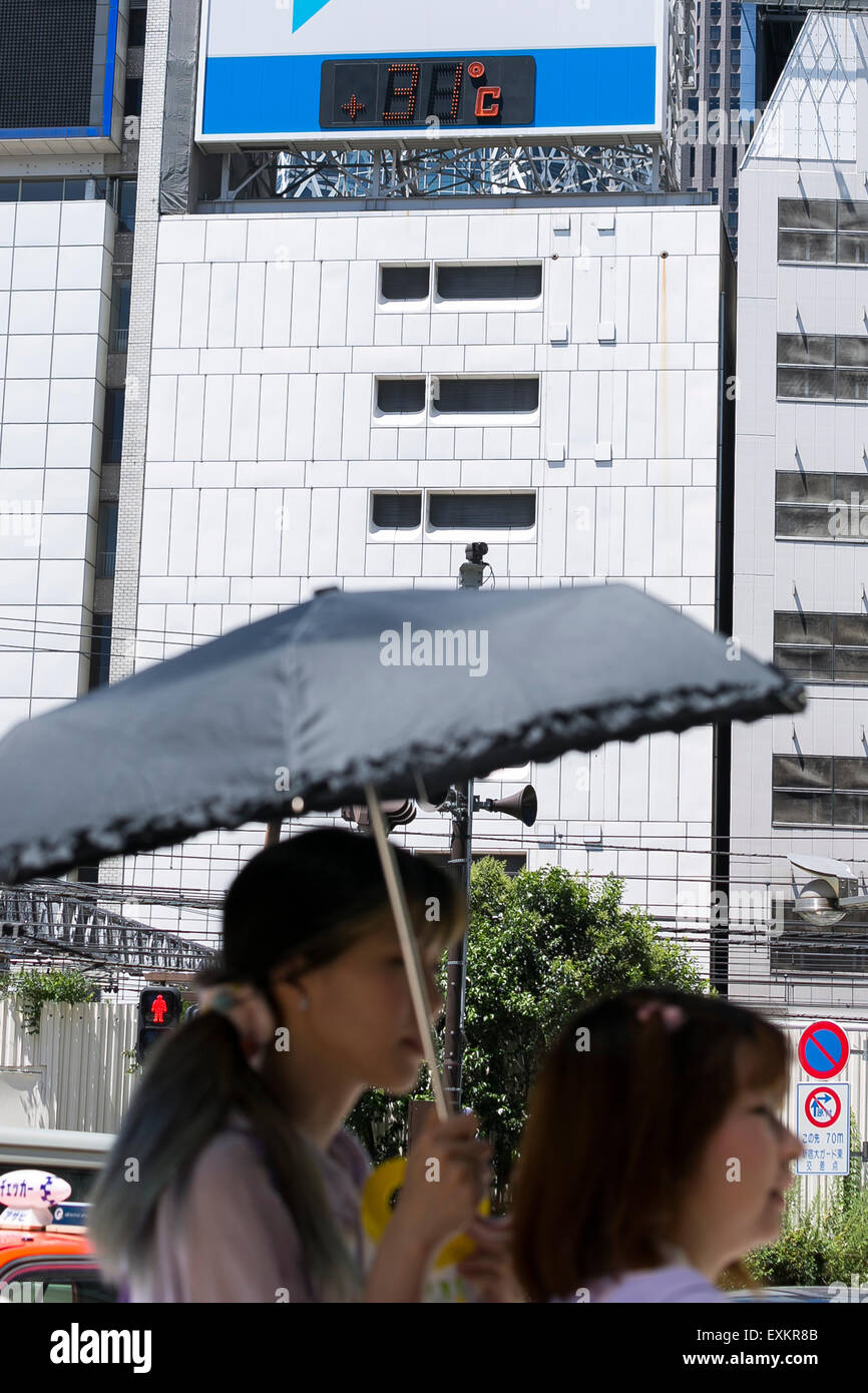 Pedestrians hold parasols to get some shade in the hot weather in ...