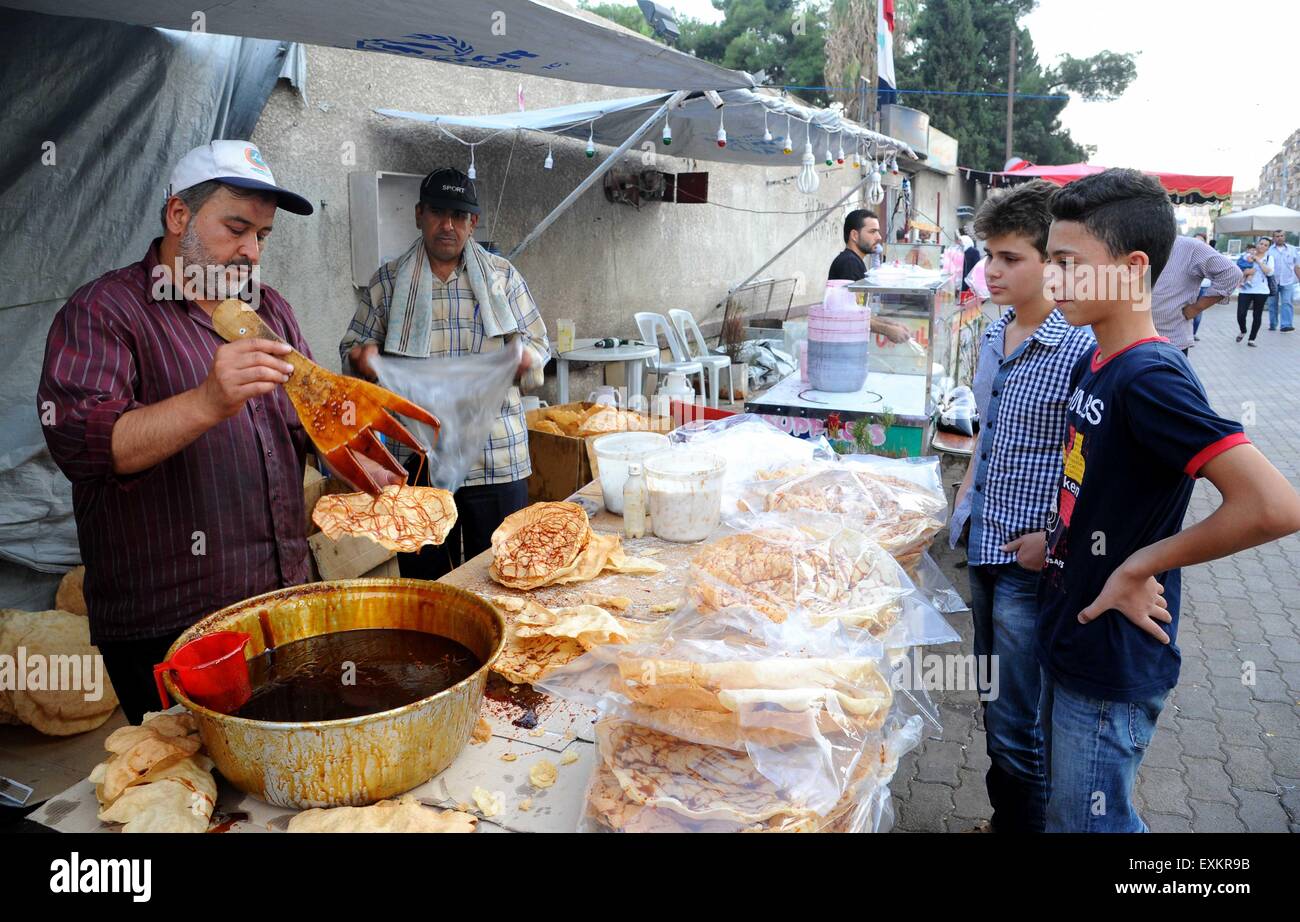 Damascus, Syria. 14th July, 2015. A Syrian vendor prepares Naem, a ...