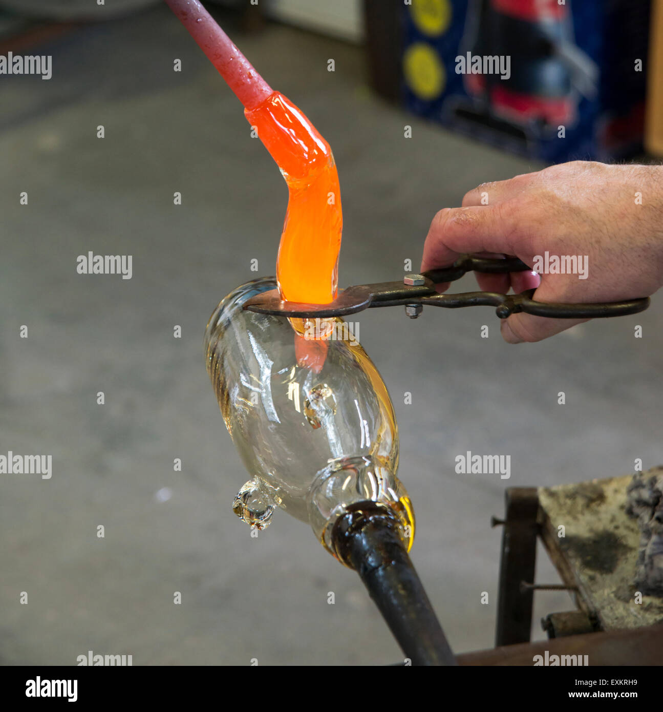 Glassblower cuts molten glass with a hand tool Stock Photo - Alamy