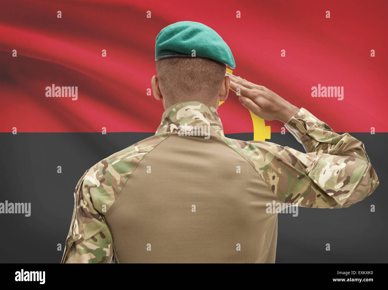 Dark-skinned soldier in hat facing national flag series - Angola Stock ...