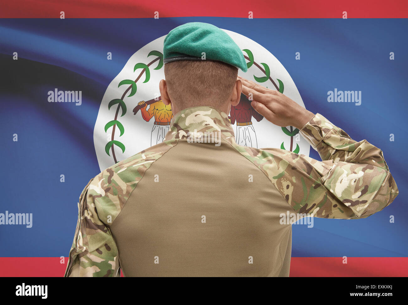 Dark-skinned soldier in hat facing national flag series - Belize Stock ...
